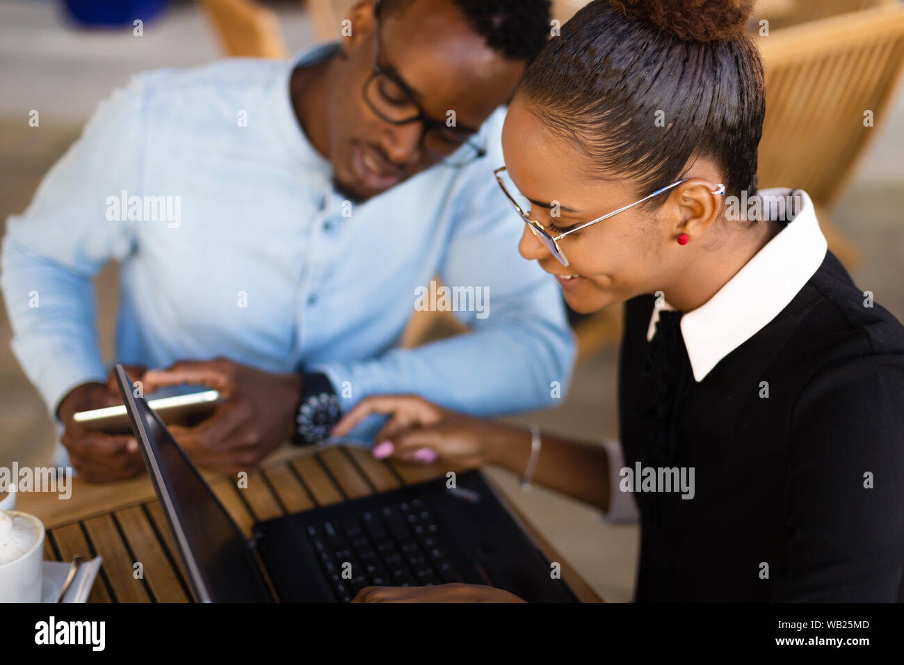 Black African American coworkers doing digital teamwork arround a ...