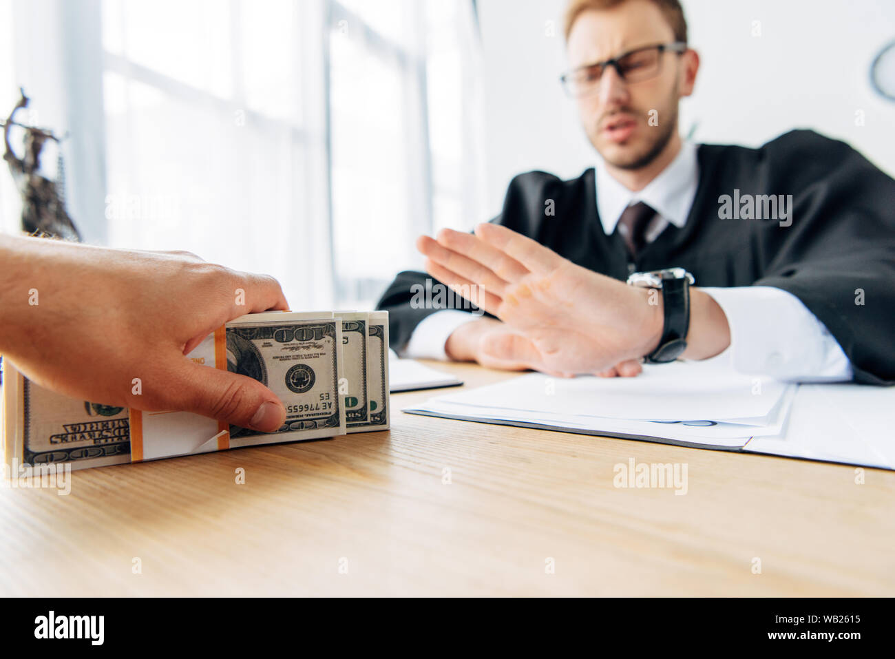 top view of man giving bribe to judge holding pen in office Stock Photo ...