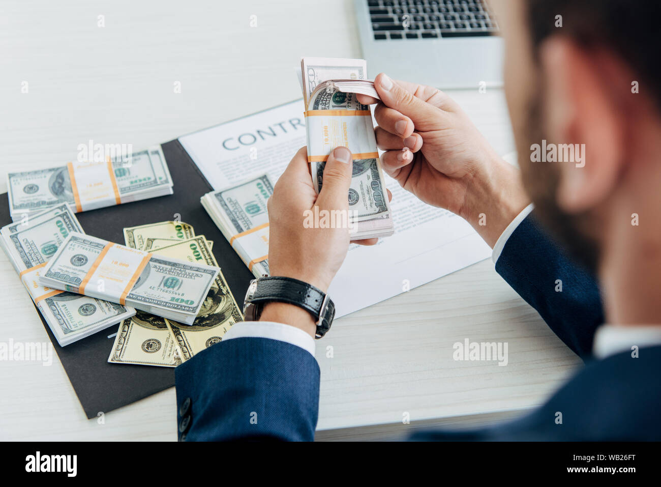 top view of businessman near laptop with blank screen touching bribe ...