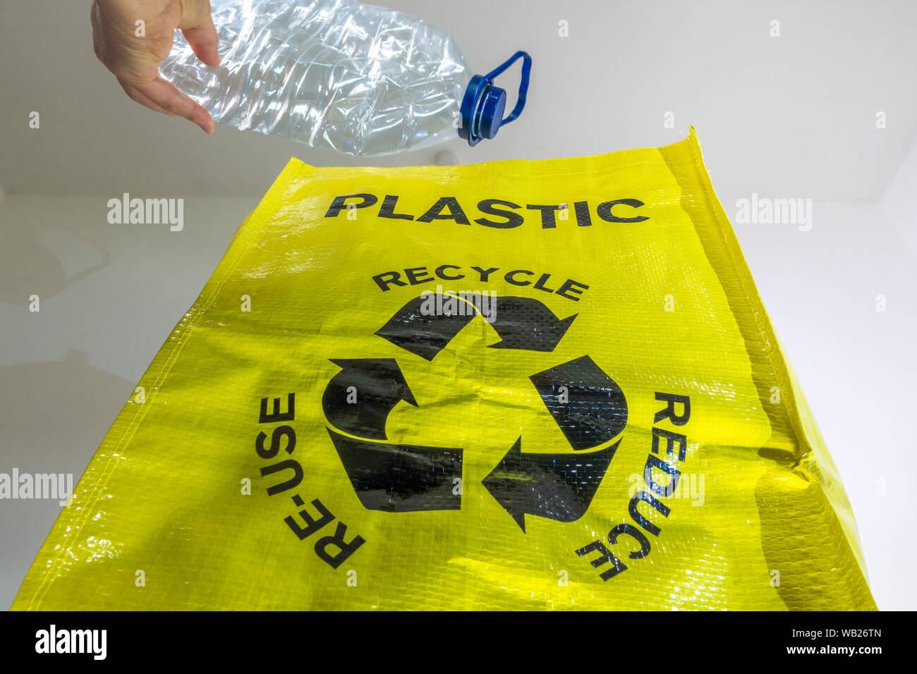 Close shot of a man’s hand placing an empty, squashed water bottle into ...