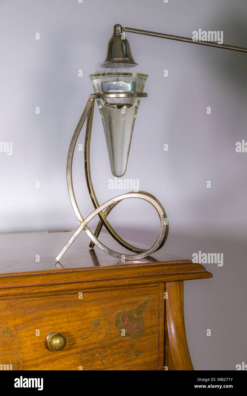 Close shot of a traditional ornate snuffer extinguishing a small ...