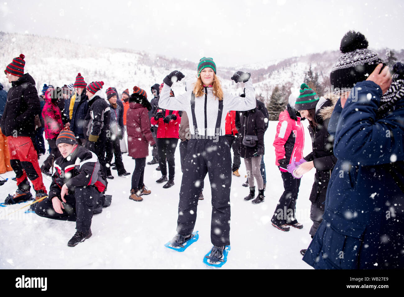 portrait of young happy woman with her business team enjoying snowy ...