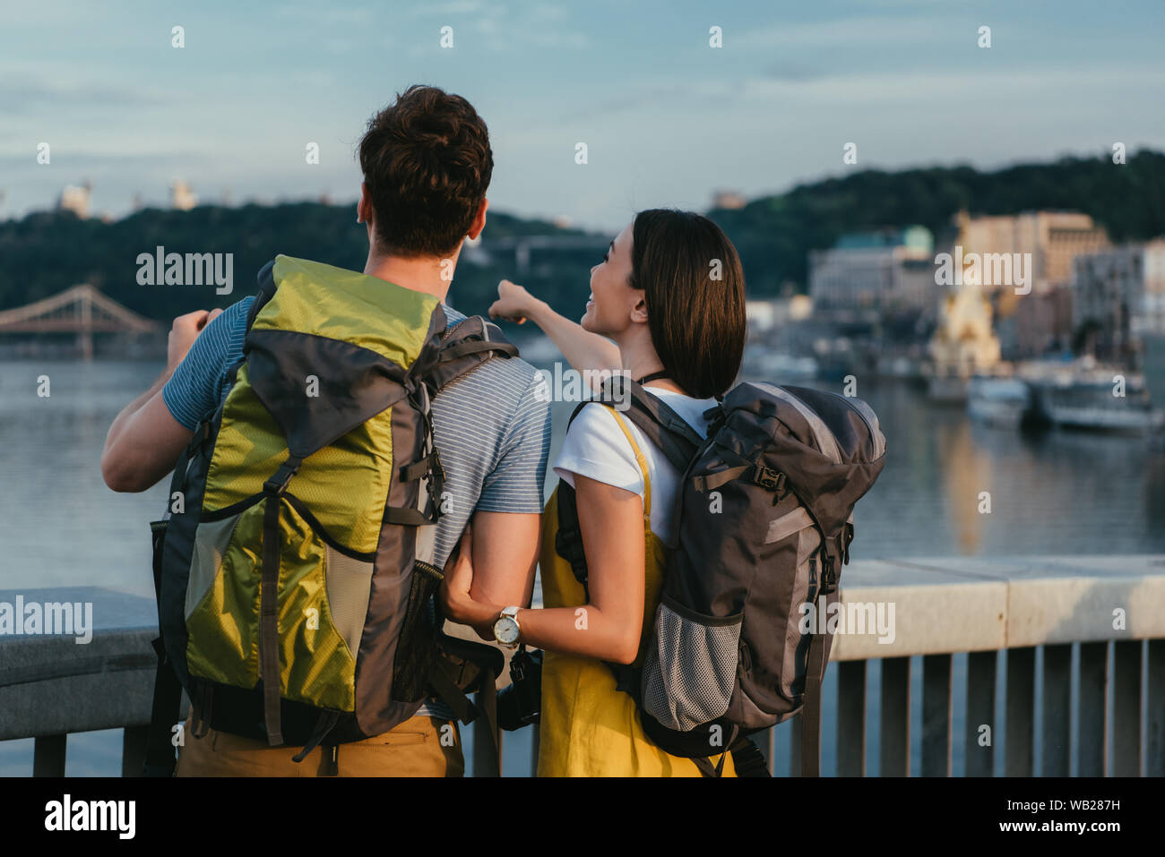 back view of man with backpack and woman pointing with finger Stock ...