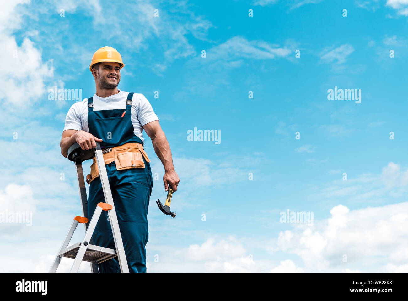 Workman Standing by a Ladder Stock Photo - Alamy