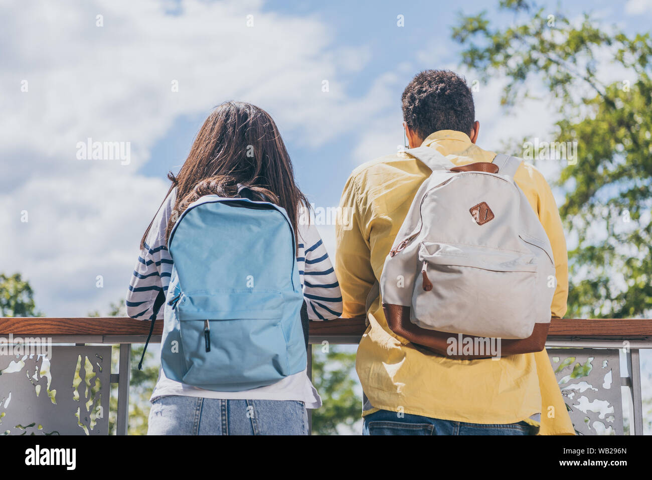 back view of multicultural travelers standing with backpacks Stock ...