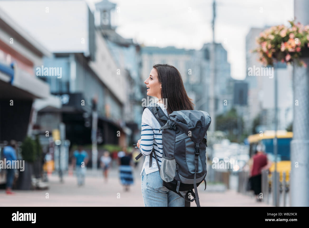 Back view of woman with backpack walking on street Stock Photo - Alamy
