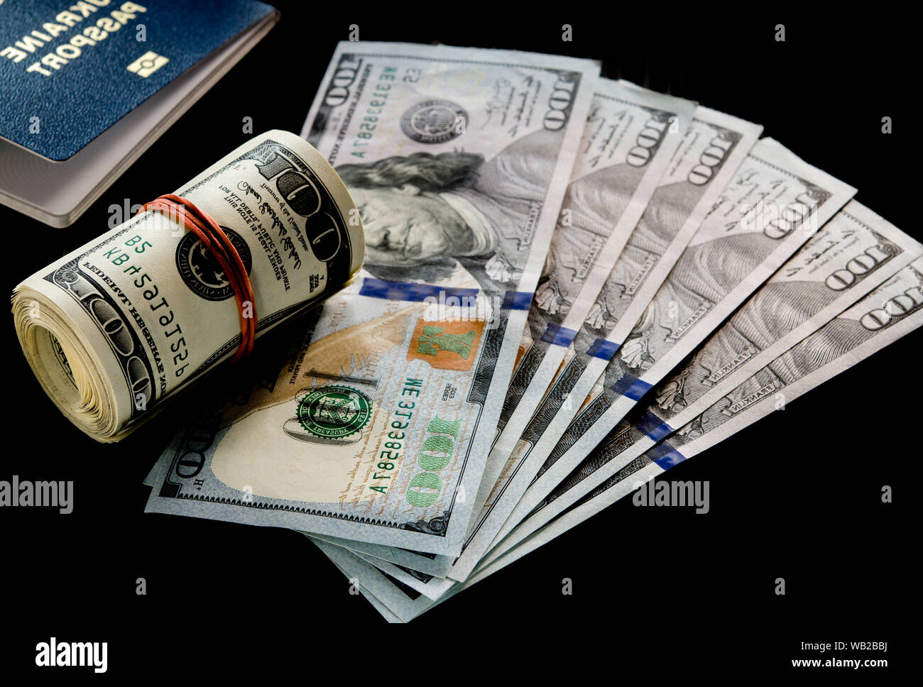 A thick roll of old hundred dollar banknotes tied a red rubber band ...