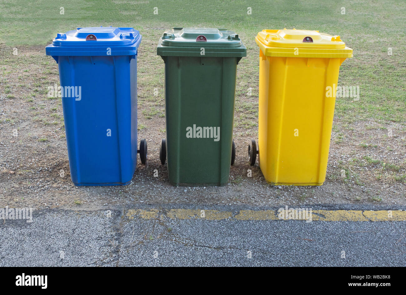 three lockable recycle trash bins (blue, green, yellow) used for ...