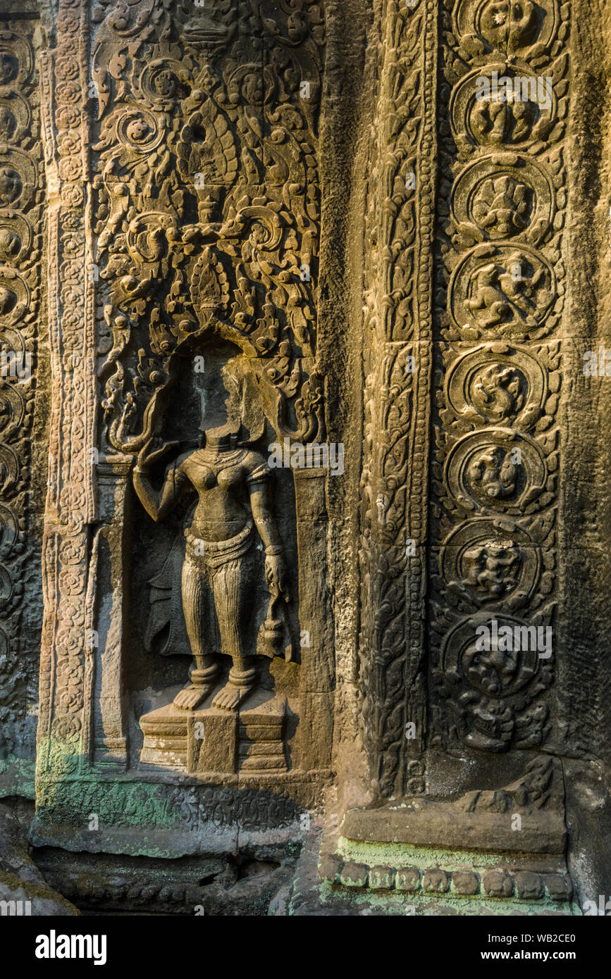 a statue of devata whose face was sliced in Ta Prohm temple, Khmer ...