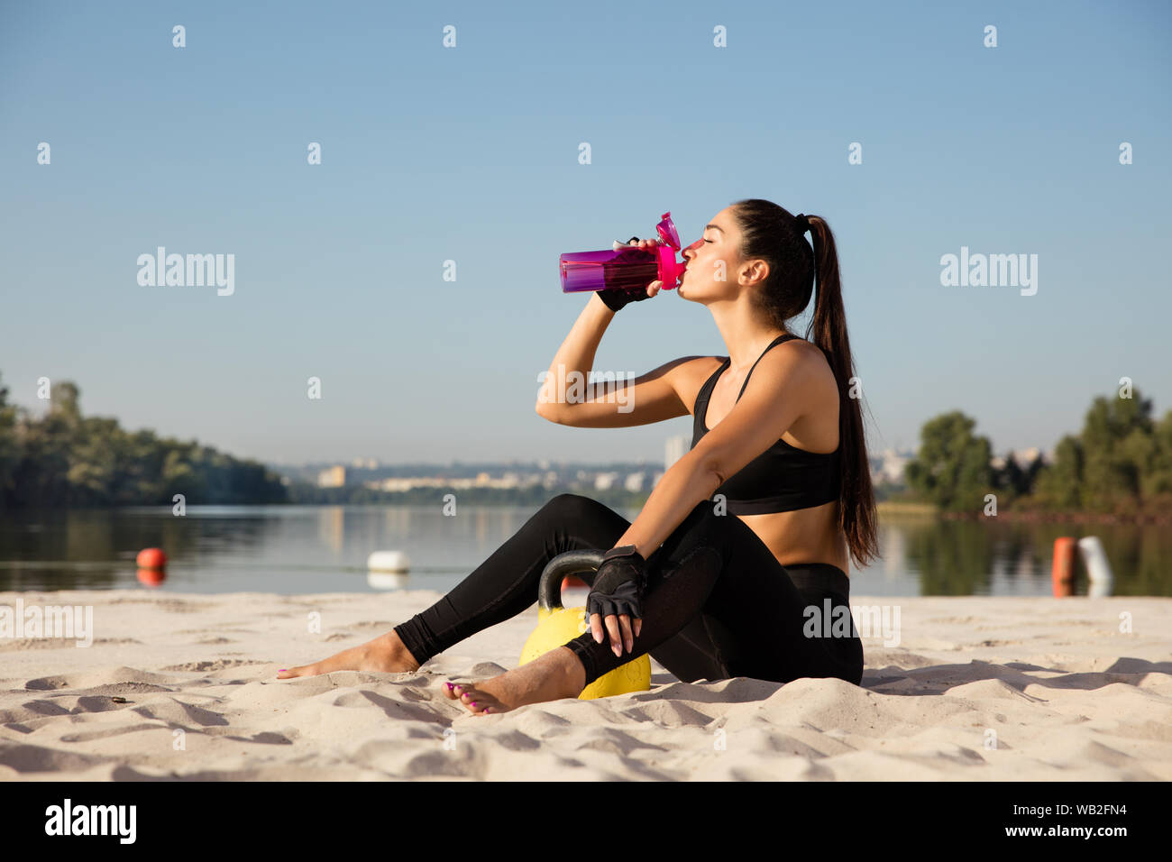 Young healthy woman resting after practicing at the beach. Single ...
