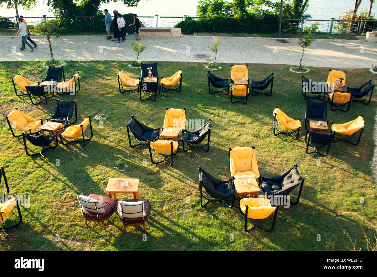 Armchairs bags and tables on the grass in a cafe. View from above. The ...