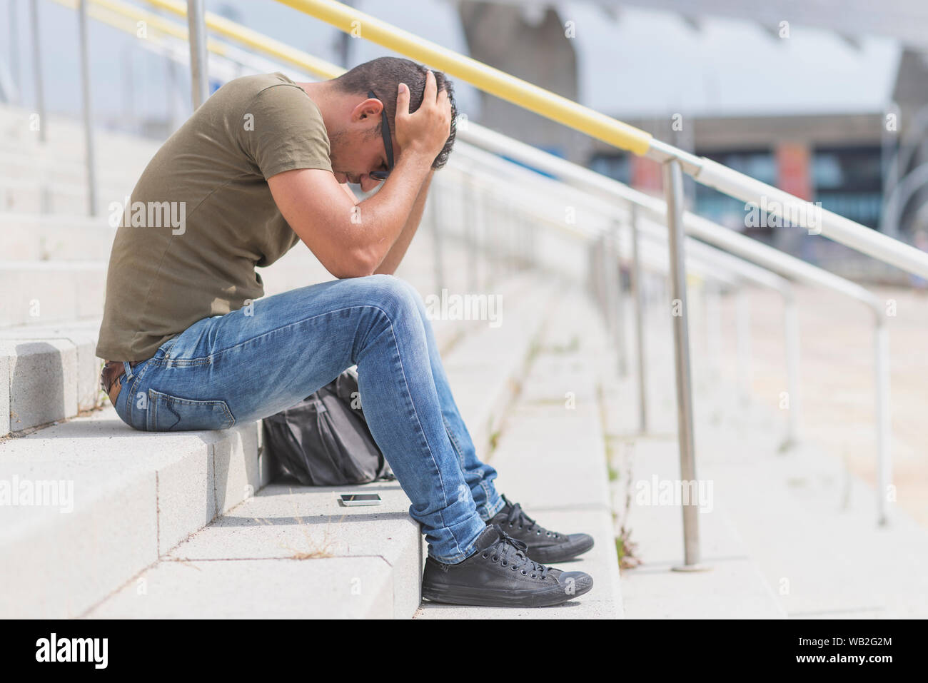 A young man lost in depression sitting Stock Photo - Alamy