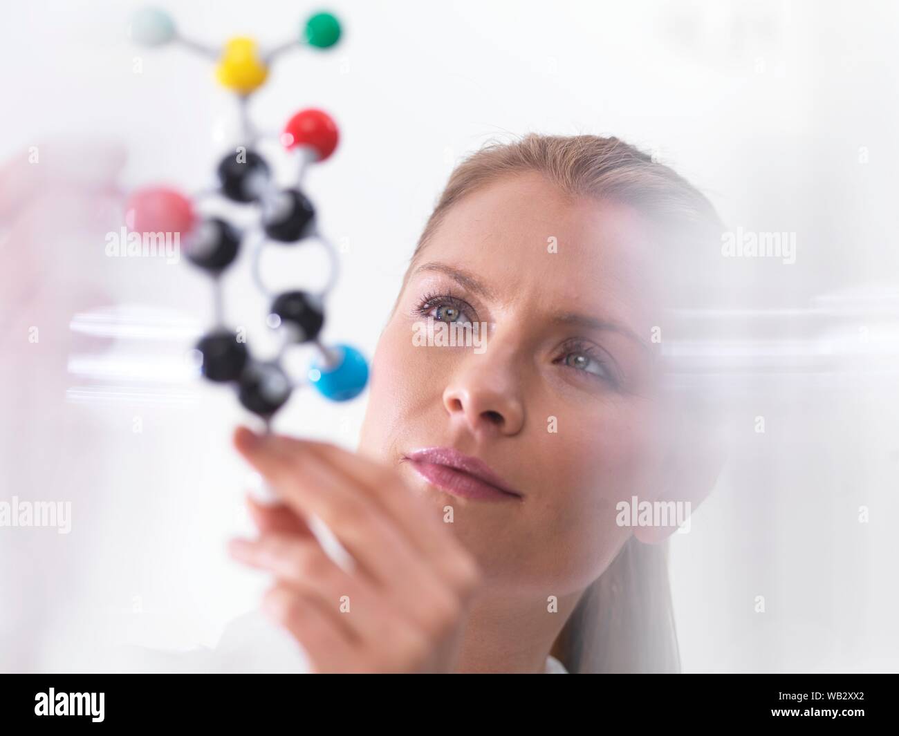 Chemistry research, conceptual image. Scientist using a molecular model ...