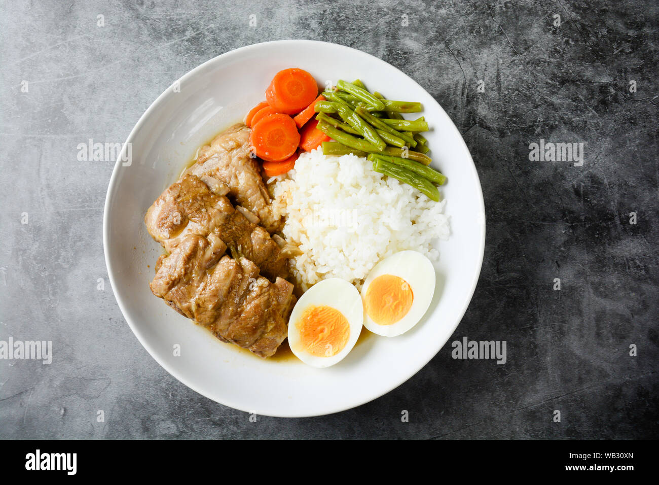 Baked pork ribs with rice, boiled egg and vegetable Stock Photo - Alamy