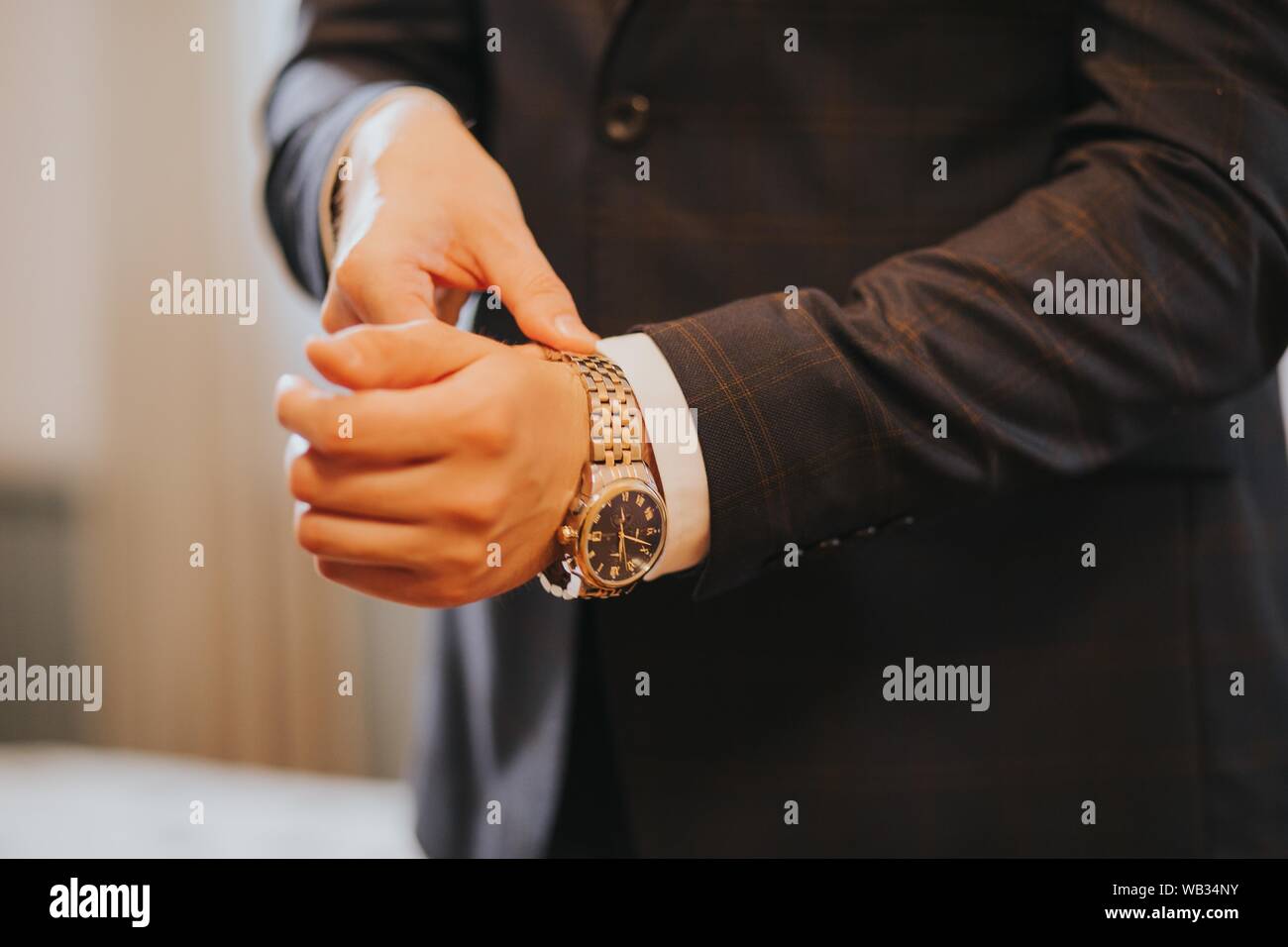 Closeup of a male's hand putting on his classic watch before the ...