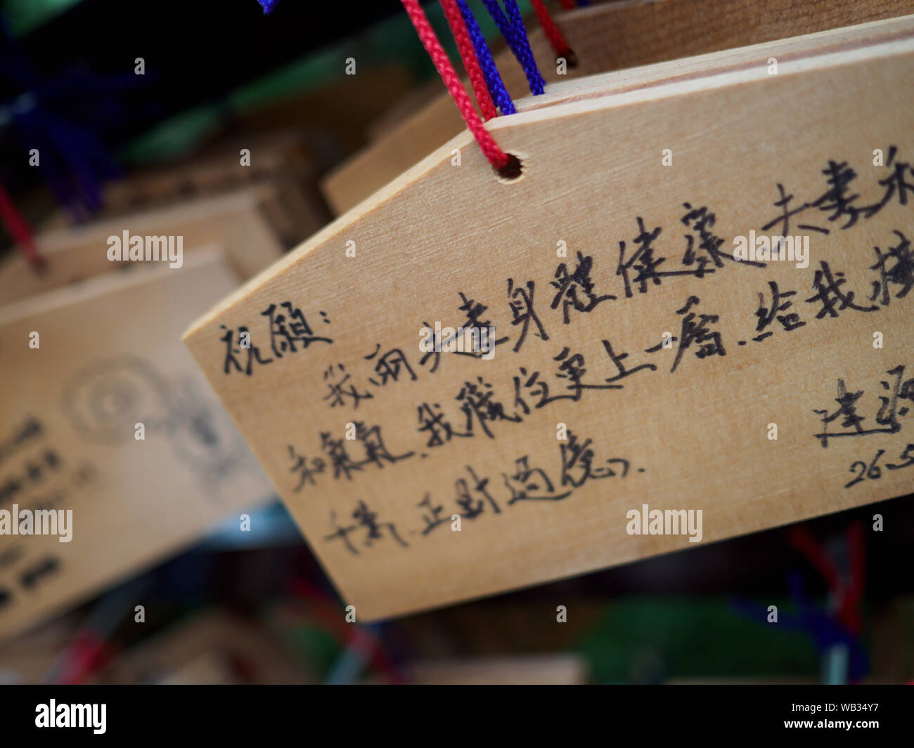 Ema wooden plaques with written prayers hanging outside a shinto shrine ...