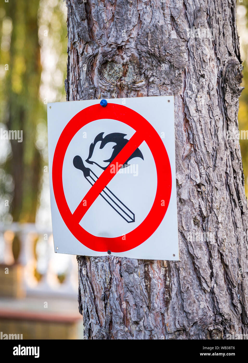 No match fire sign. Red circle with crossed match. Blurred park nature ...