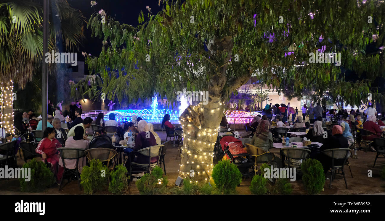 Palestinians sitting in outdoor cafe at night in the Municipality Park ...
