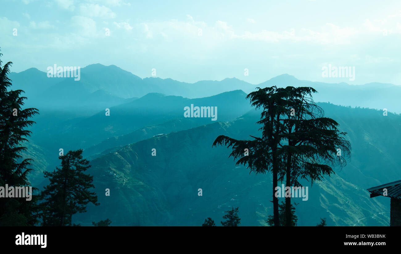 landscape with silhouettes of mountains with mist and cold sunlight ...