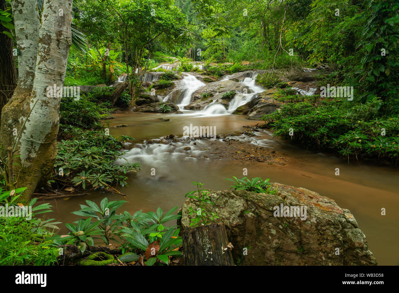 Water cascading from layer of large rocks of Mae Sa Noi waterfall with ...