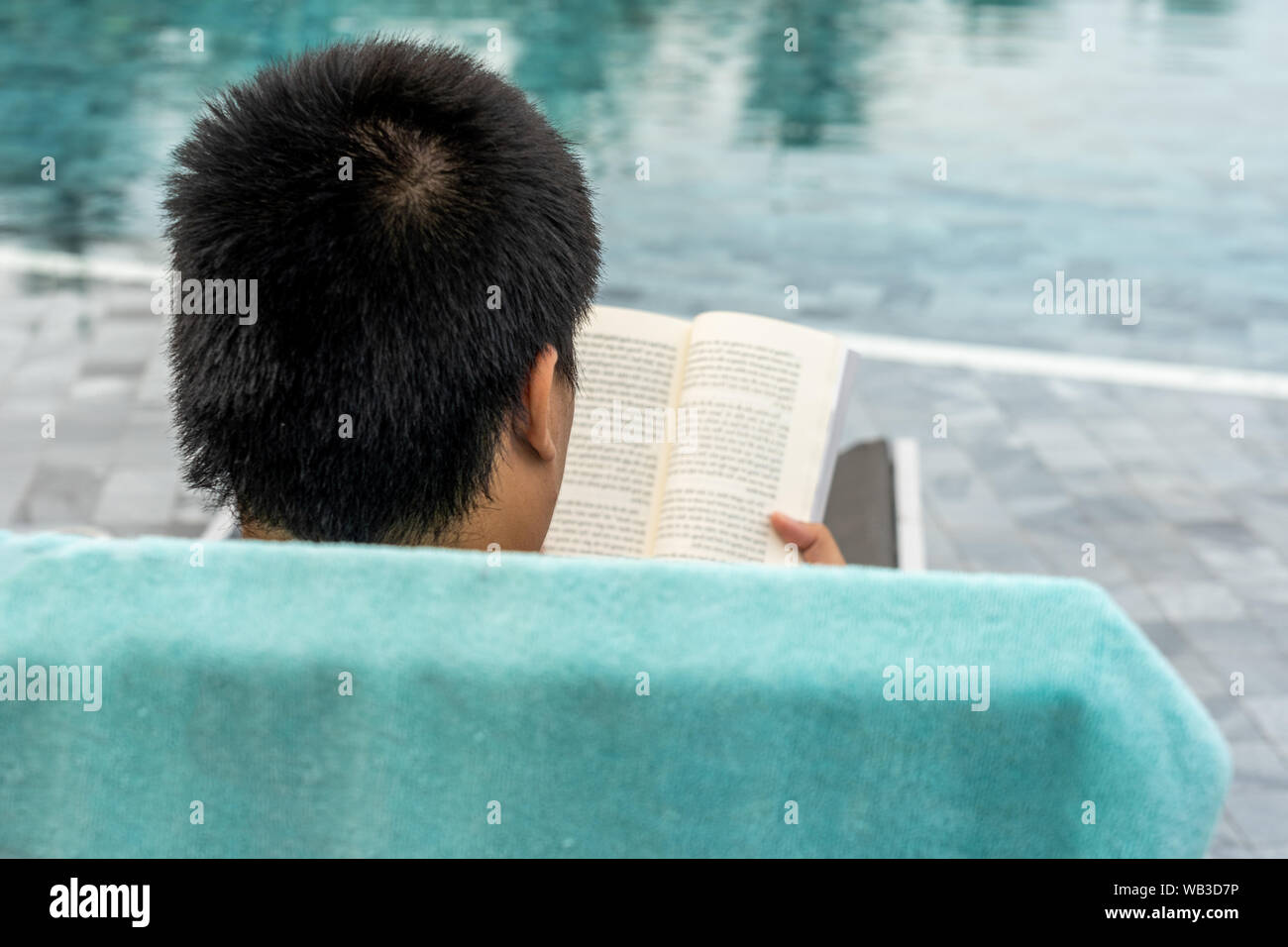 Closeup of human reading book at swimming pool Stock Photo - Alamy