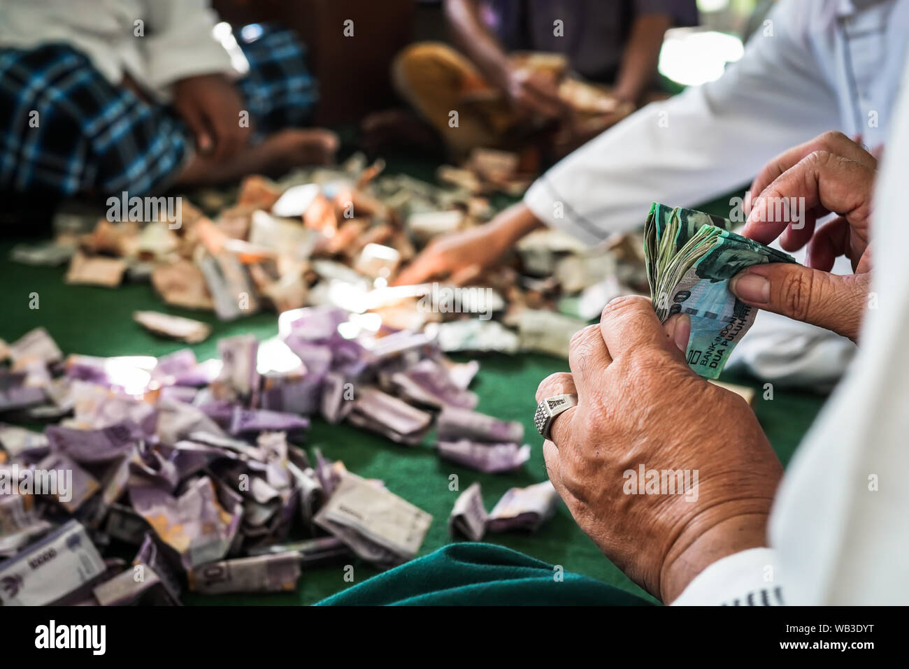 A group of men counting charity money at a mosque Stock Photo - Alamy