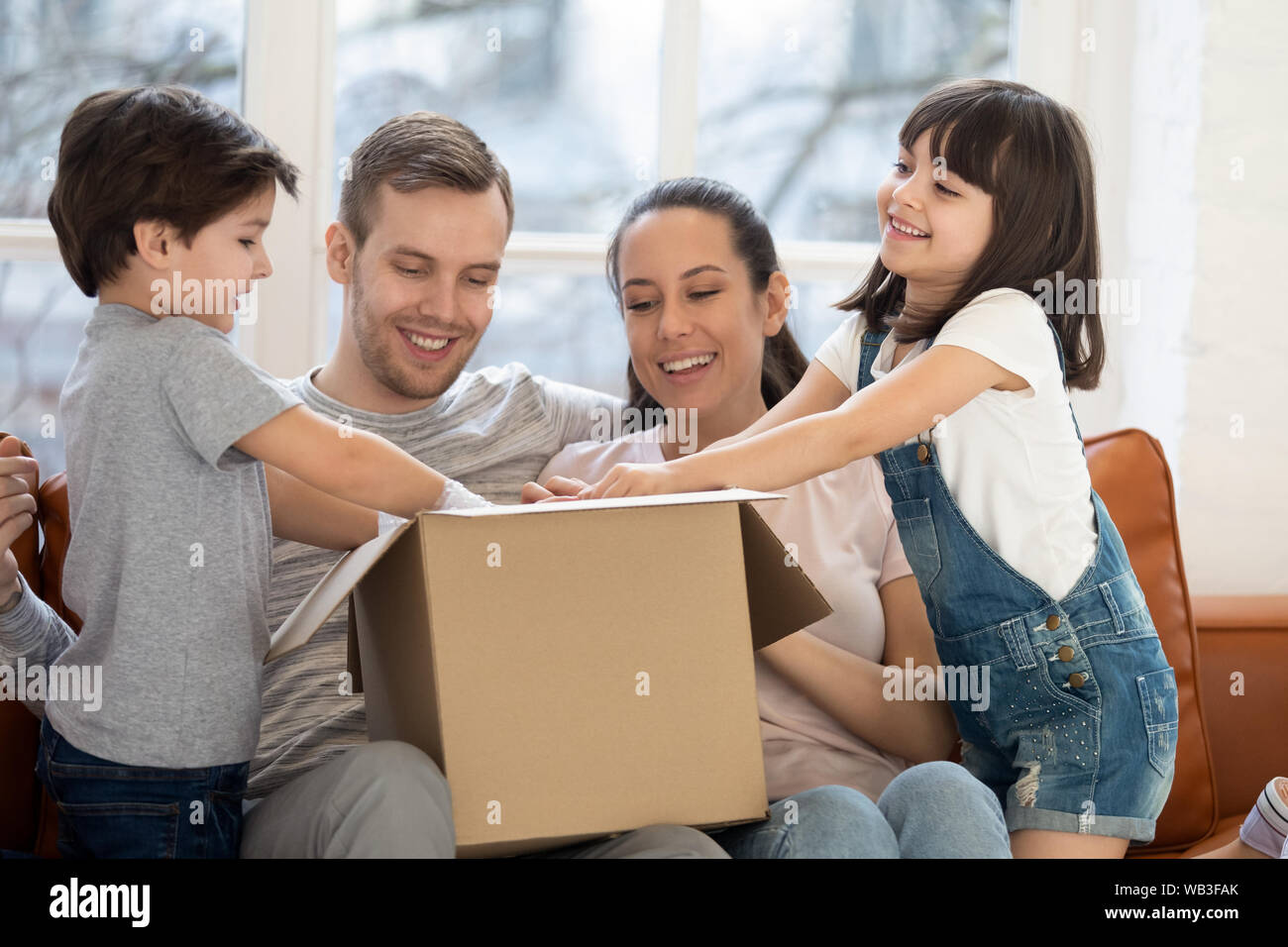 Happy family with kids customers open cardboard box at home Stock Photo ...