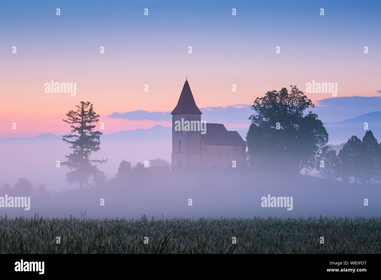 Rural Gothic church in a cemetery on a foggy morning Stock Photo - Alamy