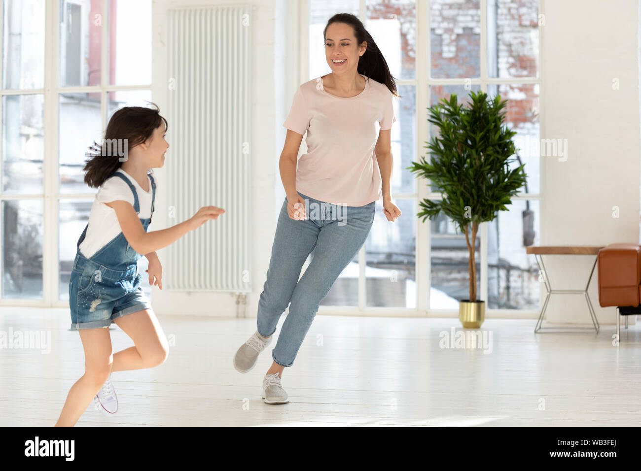 Happy mom and kid daughter playing tag and touch game Stock Photo - Alamy