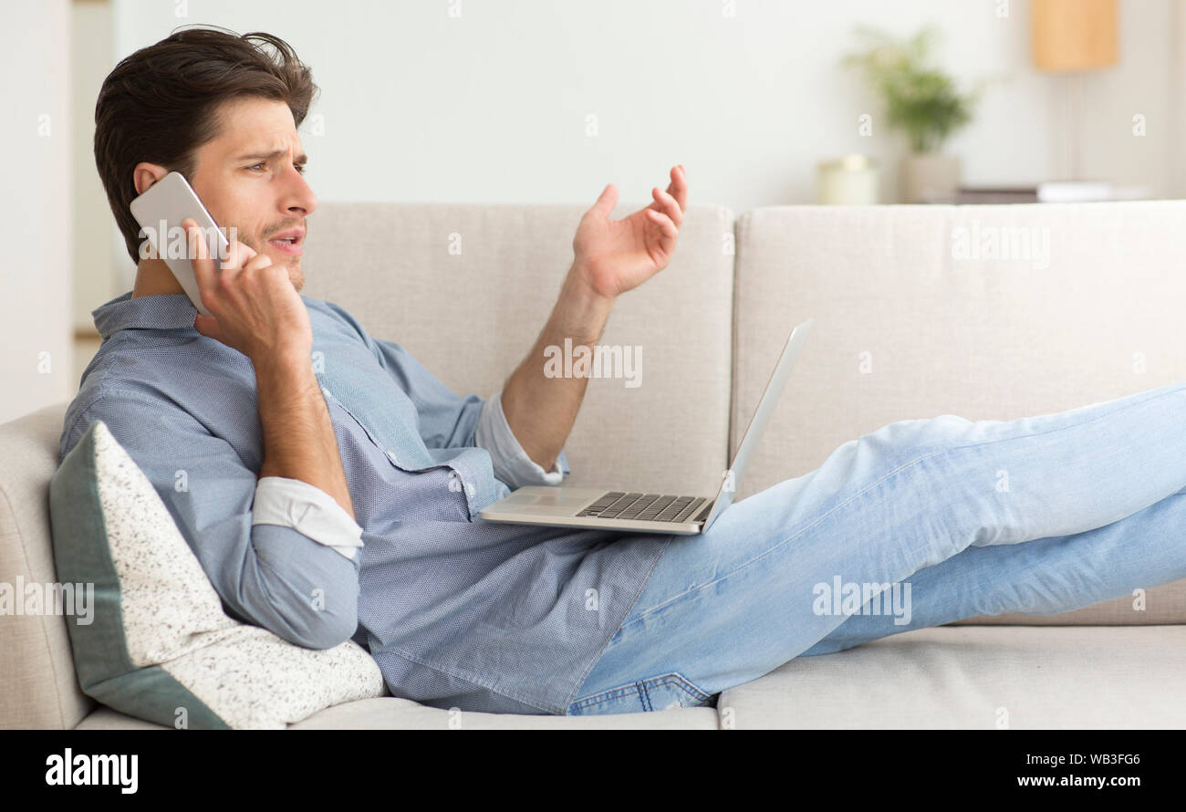 Man Complaining About Bad Service By Phone Lying On Sofa Stock Photo ...