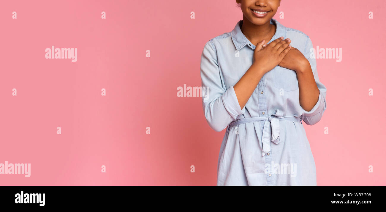 Grateful african girl pressing hands to chest Stock Photo - Alamy