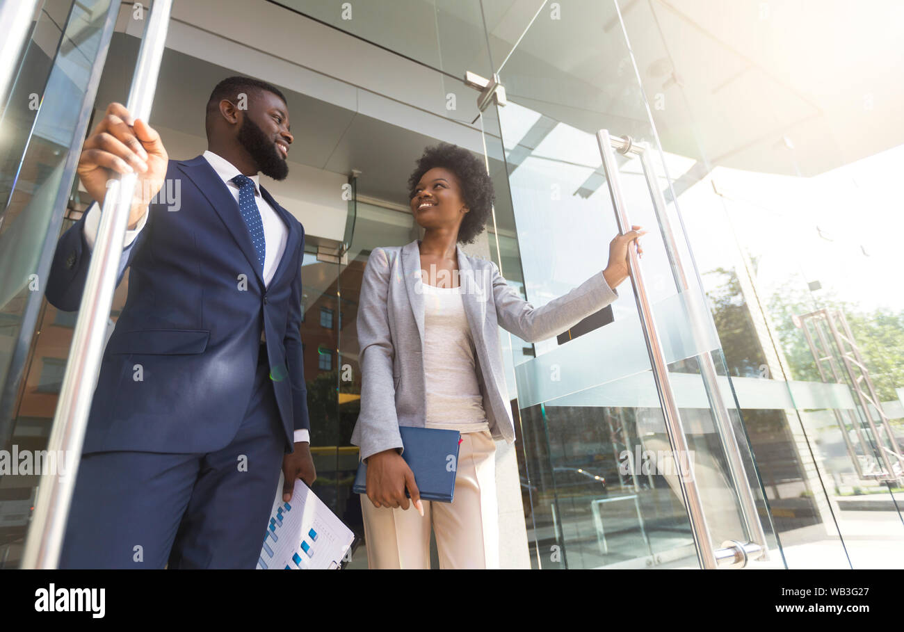 Confident african business people walking out of modern office center ...