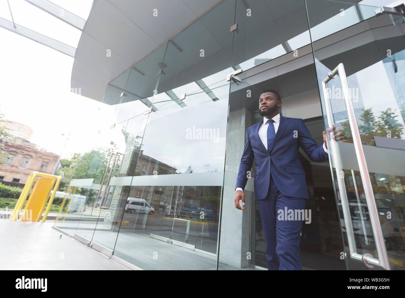 Handsome african american ceo leaving business center after meeting ...