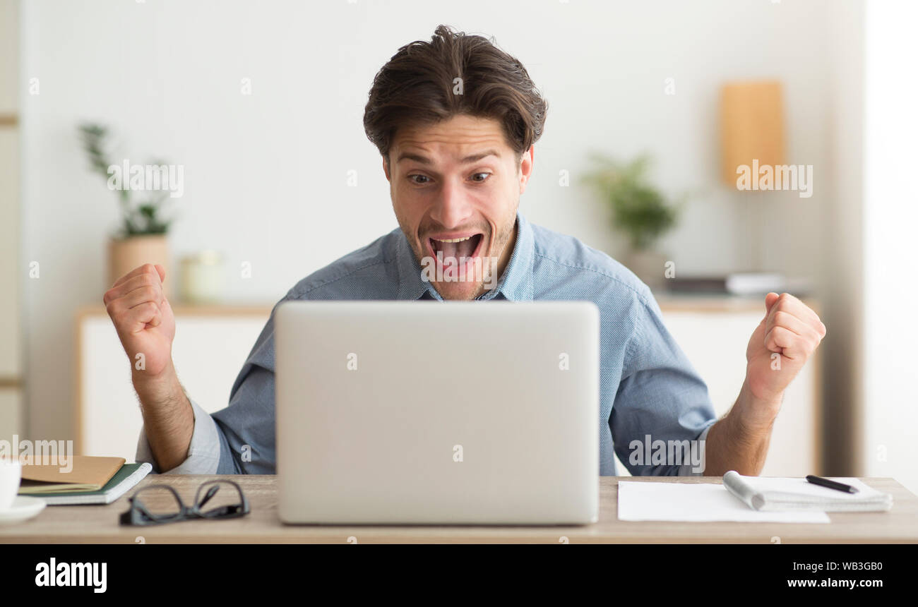Excited Man Celebrating His Victory At Laptop In Office Stock Photo - Alamy