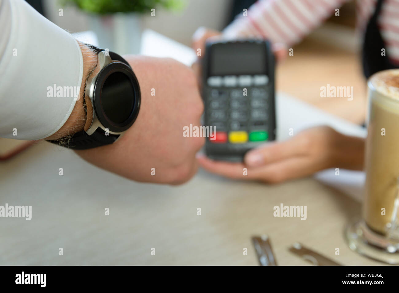 Customer making wireless or contactless payment using smartwatch. Store ...