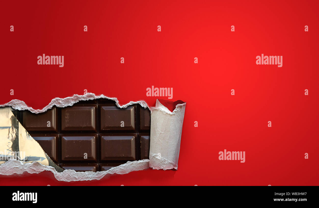 Dark chocolate bars in a red package strip open. Background with copy ...