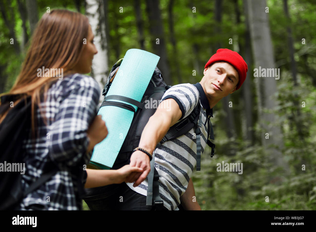 Hiker man guiding woman into the forest, travel concept Stock Photo - Alamy