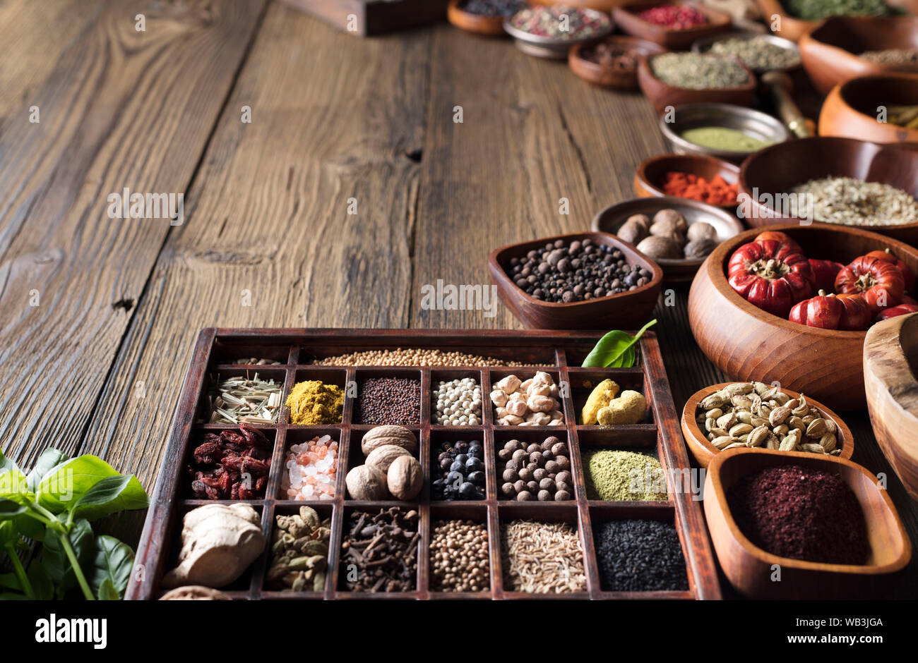 Collection of spices in bowls on wooden rustic table. Place for text or ...
