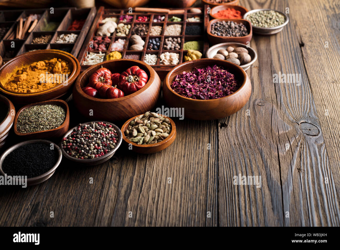 Collection of spices in bowls on wooden rustic table. Place for text or ...