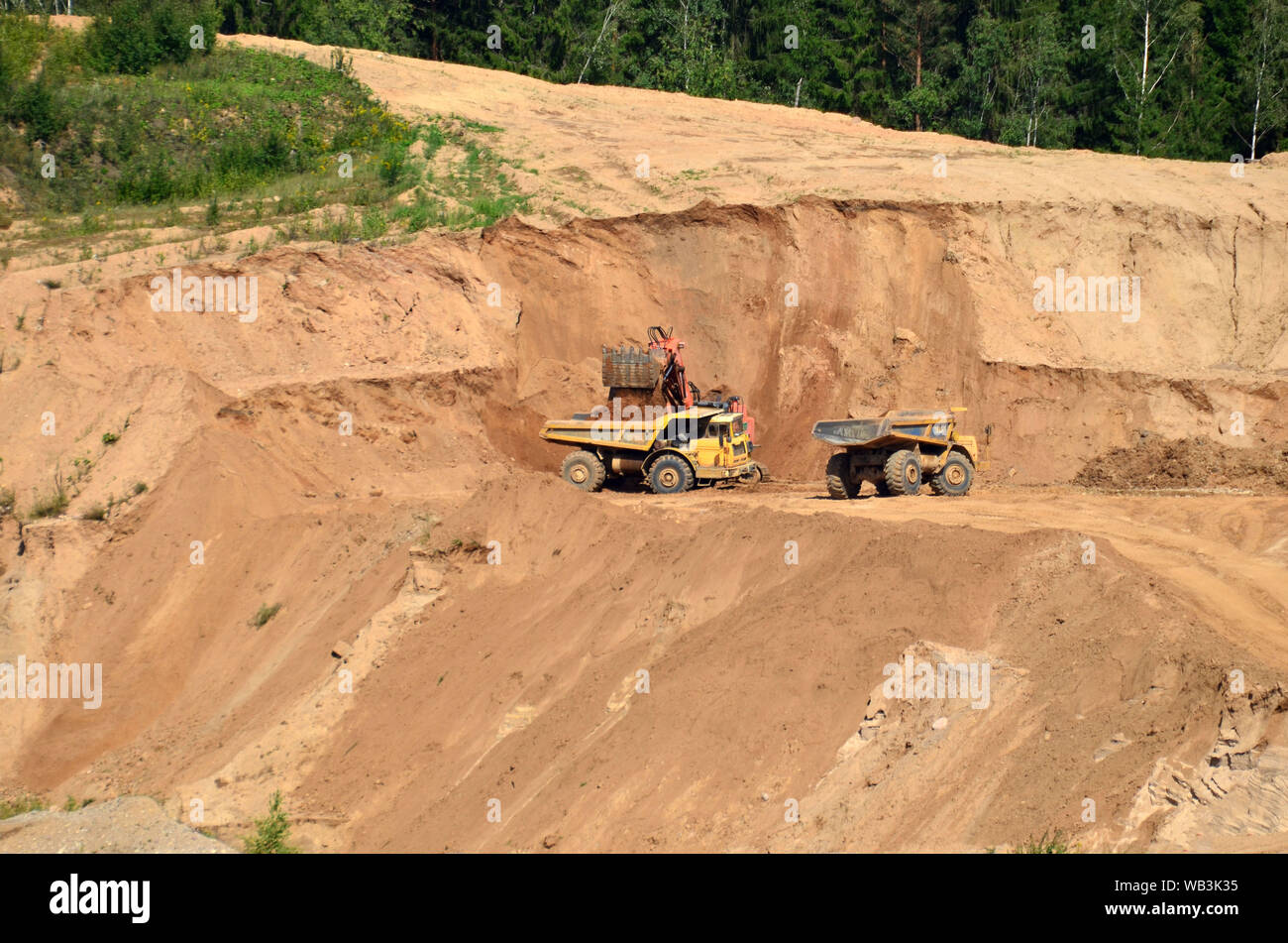 Excavator developing the sand on the opencast and loading it to the ...