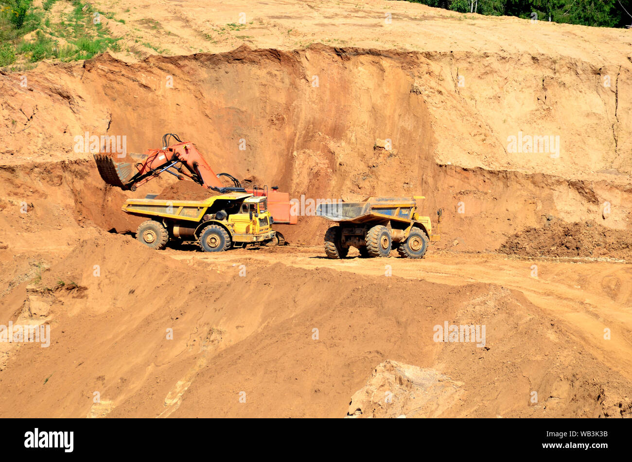 Excavator developing the sand on the opencast and loading it to the ...