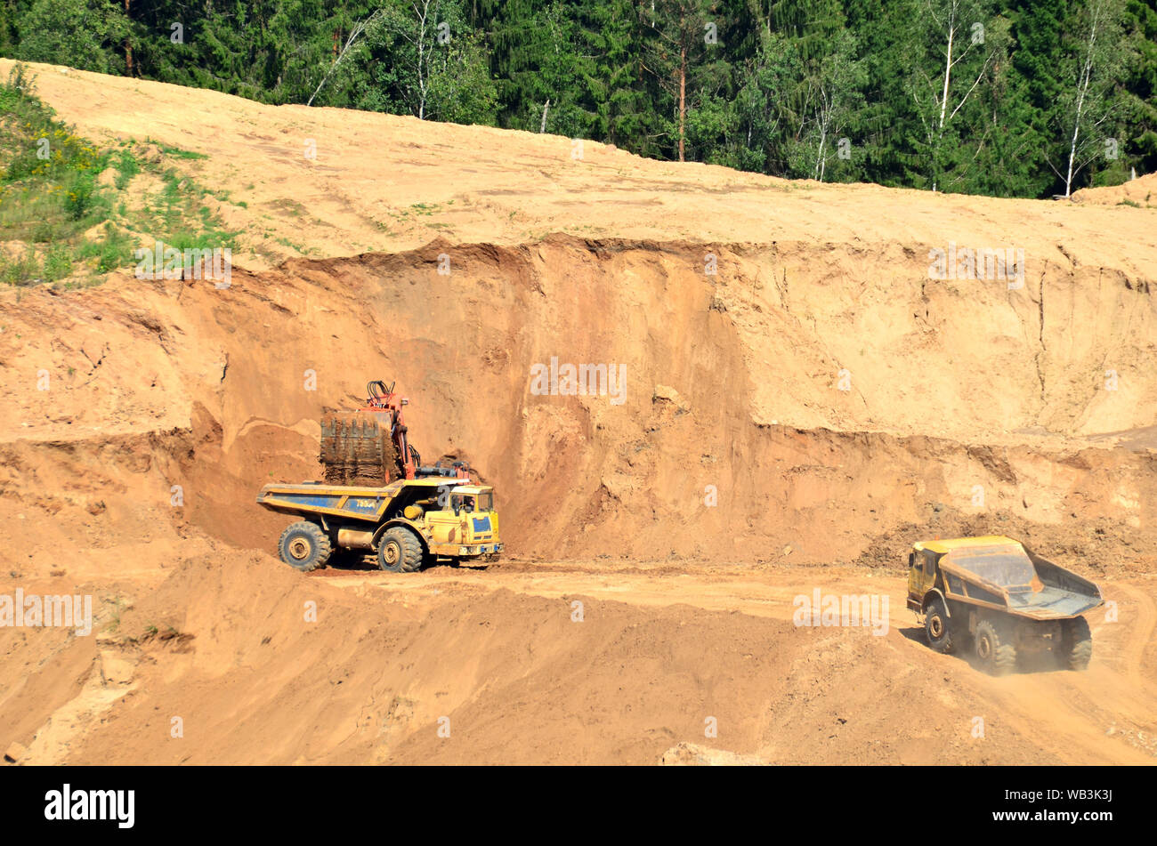 Excavator developing the sand on the opencast and loading it to the ...