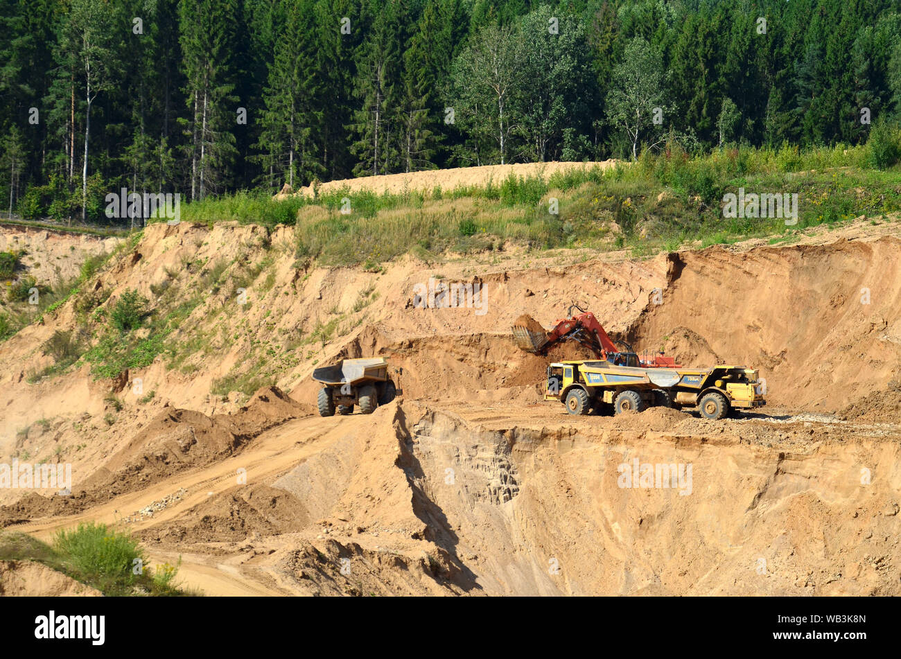 Excavator developing the sand on the opencast and loading it to the ...