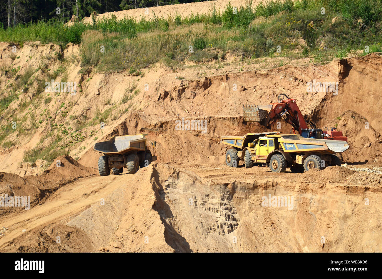 Excavator developing the sand on the opencast and loading it to the ...