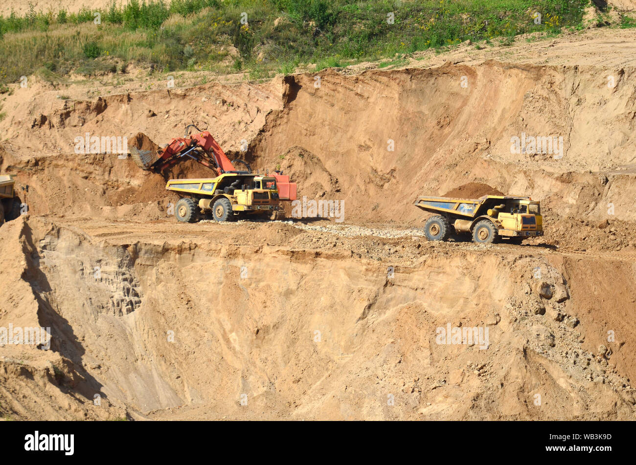 Excavator developing the sand on the opencast and loading it to the ...