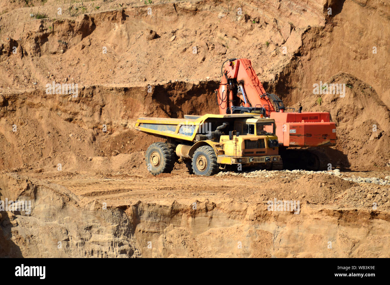 Excavator developing the sand on the opencast and loading it to the ...
