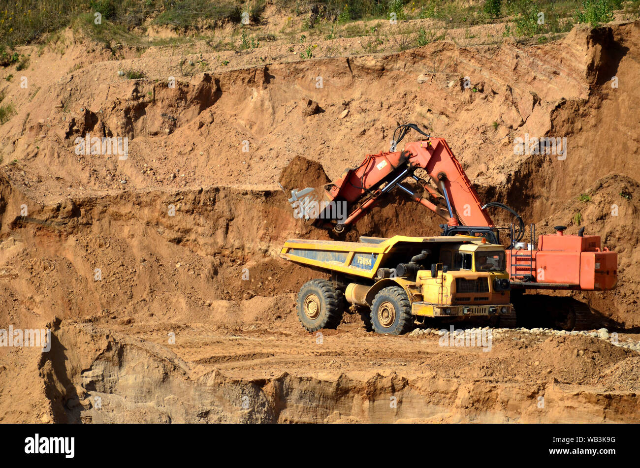 Excavator developing the sand on the opencast and loading it to the ...