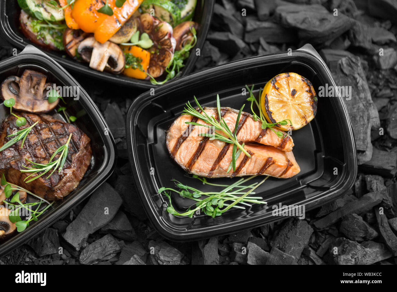 Set of grilled food in to go black boxes on coal Stock Photo - Alamy