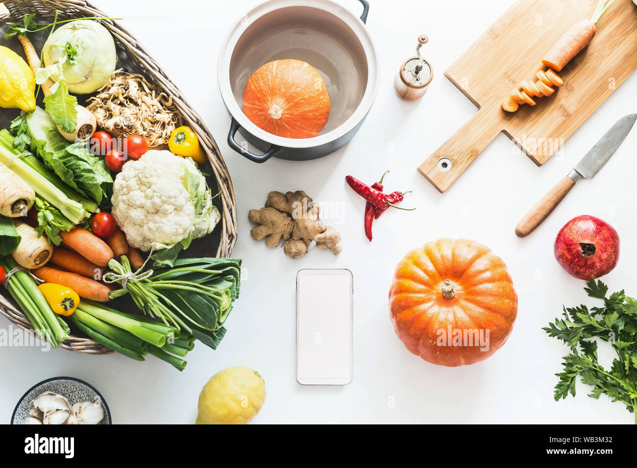 Seasonal cooking flat lay. Smartphone with blank white screen and fresh ...