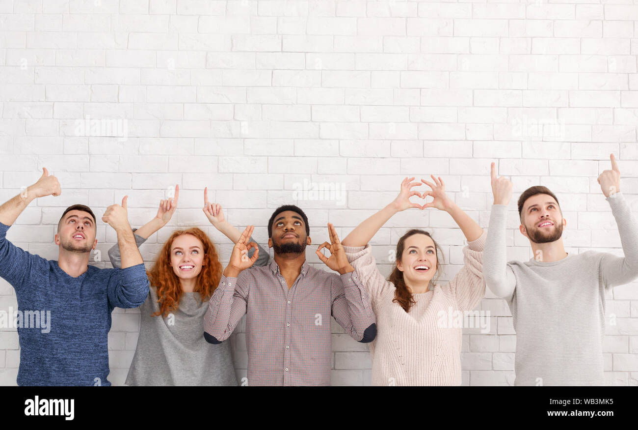 Young friends showing various gestures over white wall Stock Photo - Alamy